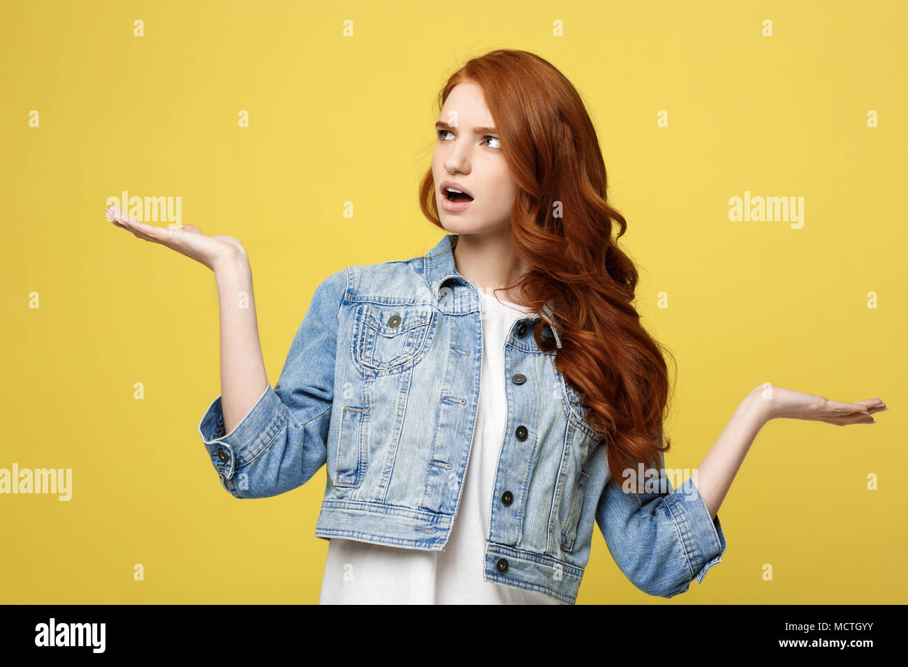 Lifestyle Concept: Surprised young woman with hand on side over golden ...