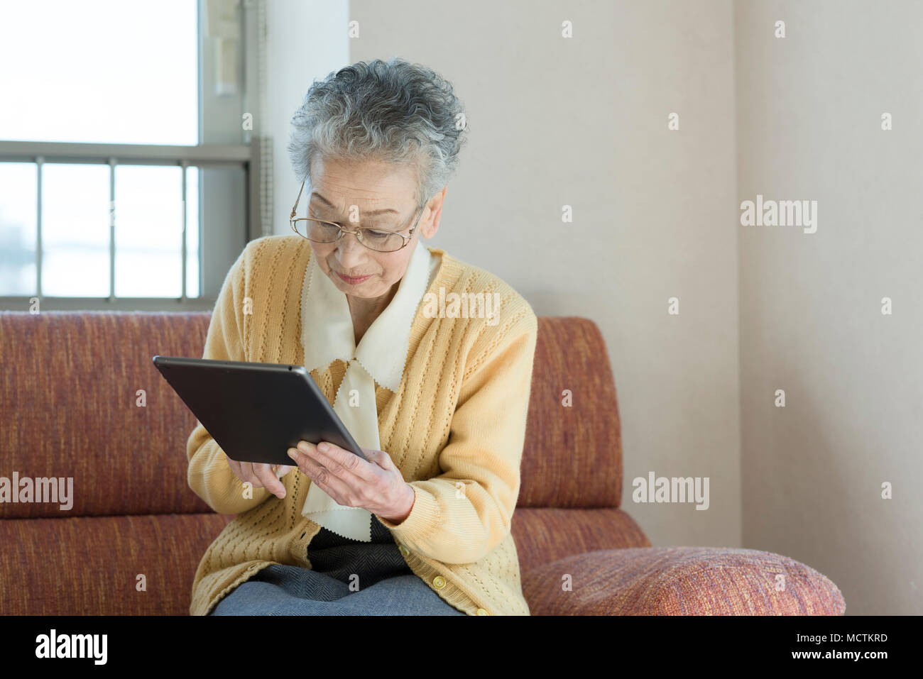 Senior woman using tablet Stock Photo - Alamy