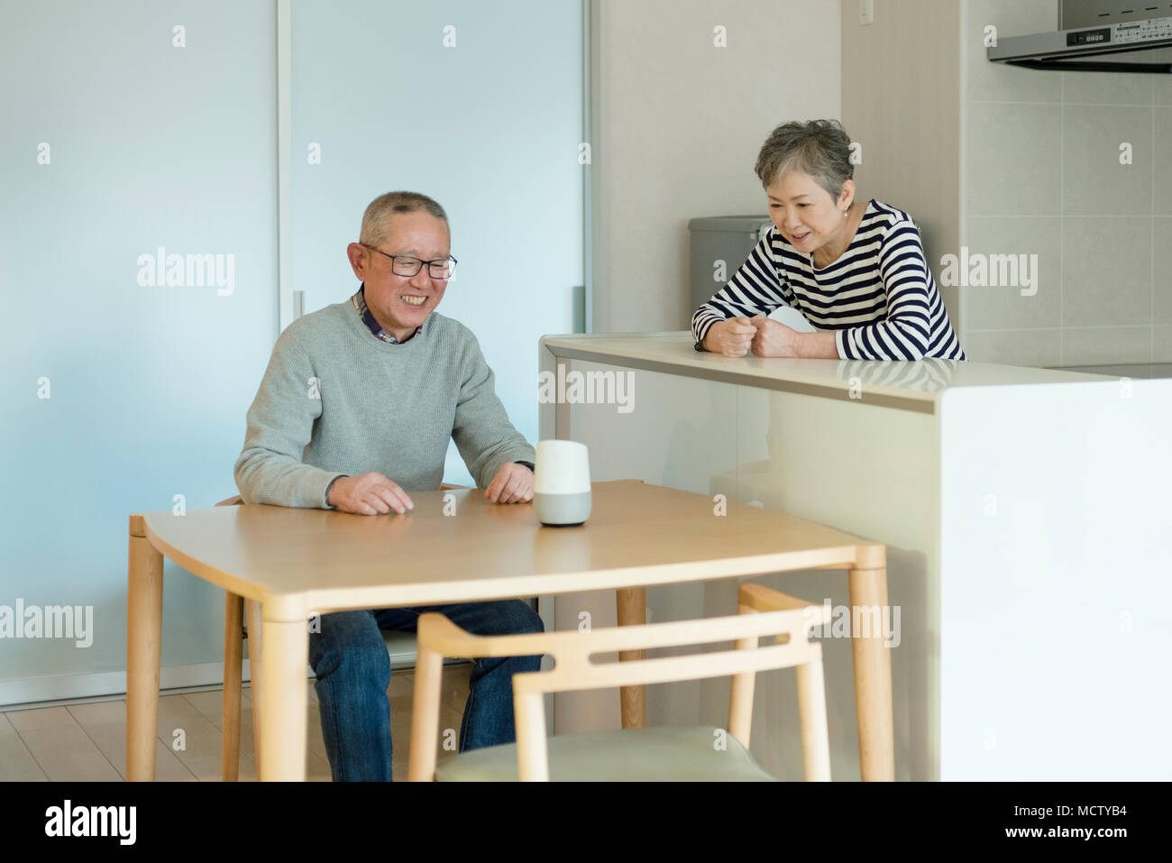 Senior couple interested in AI speaker Stock Photo - Alamy
