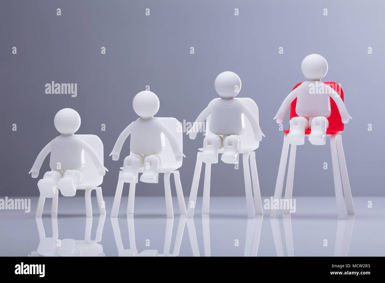 Close-up Of Human Figures Sitting On Increasing White And Red Chairs In ...