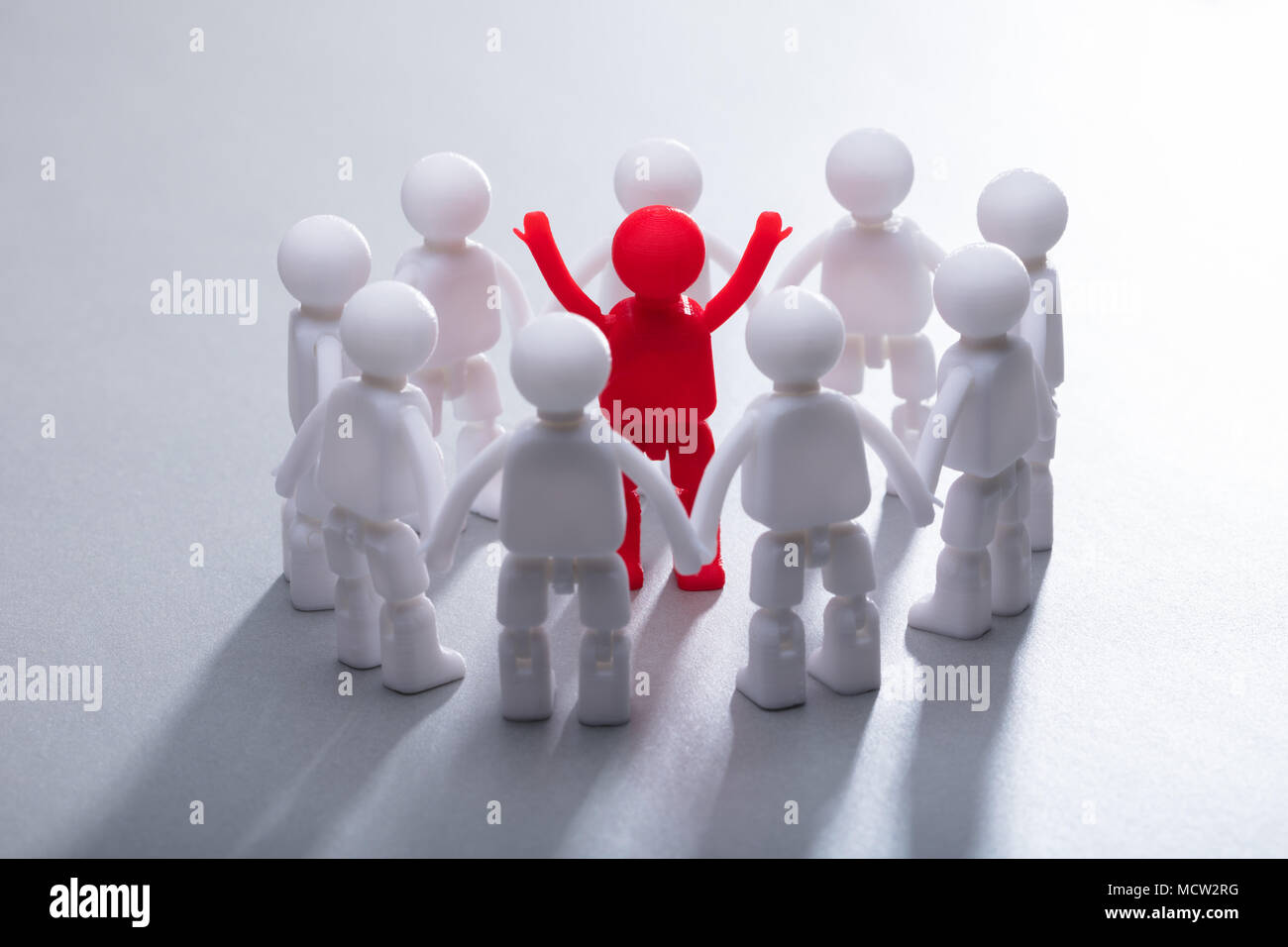 Red Human Figure Surrounded By Team Representing Unity Stock Photo - Alamy