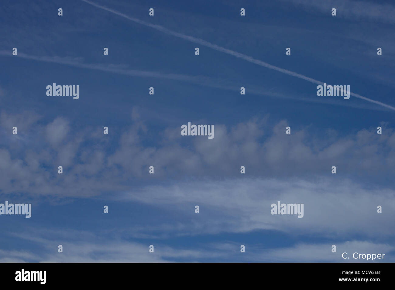 Blue sky with clouds and jet exhaust Stock Photo - Alamy