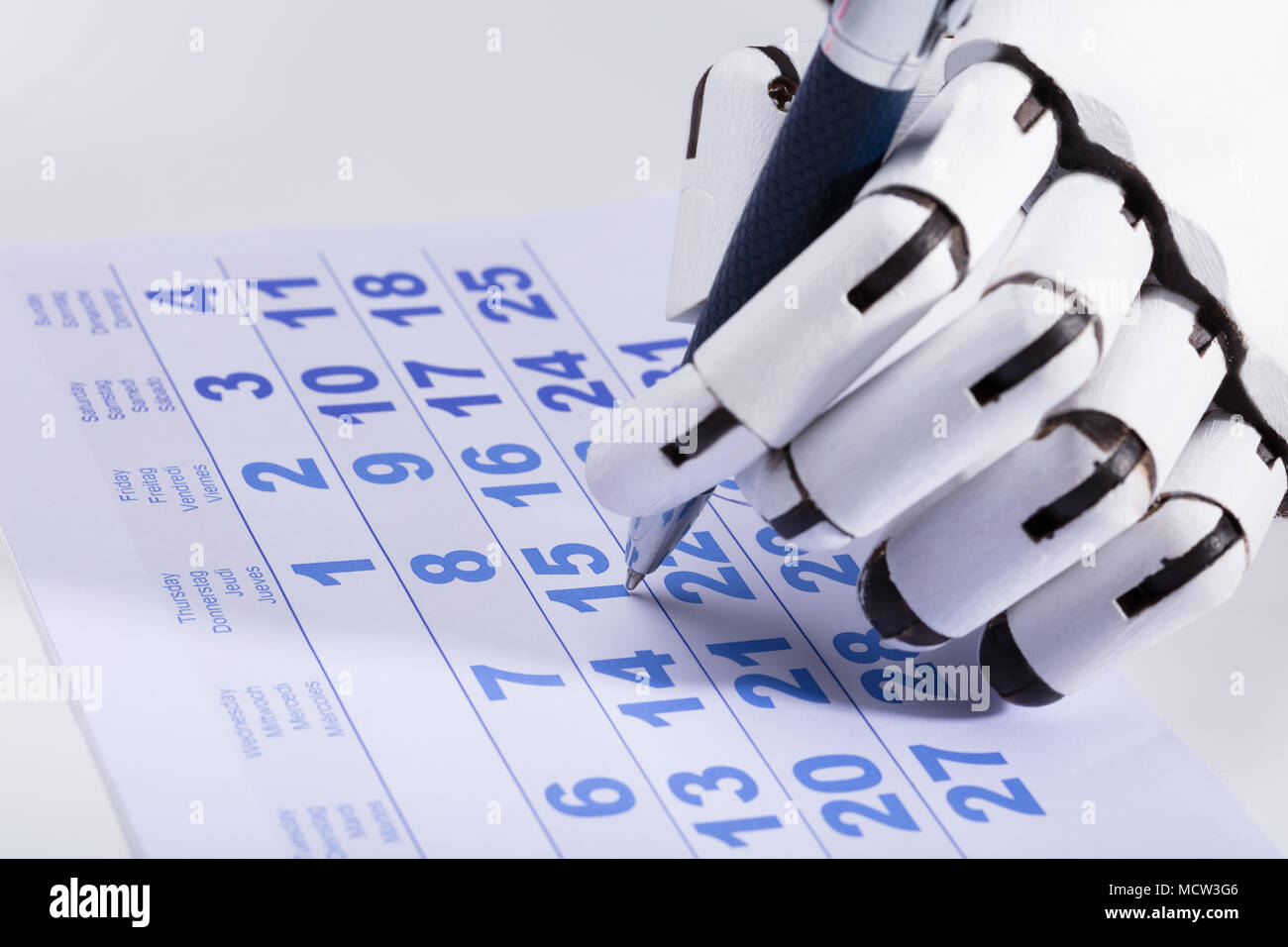 Close-up Of A Robotic Hand Marking Date On Calendar With Pen Stock ...