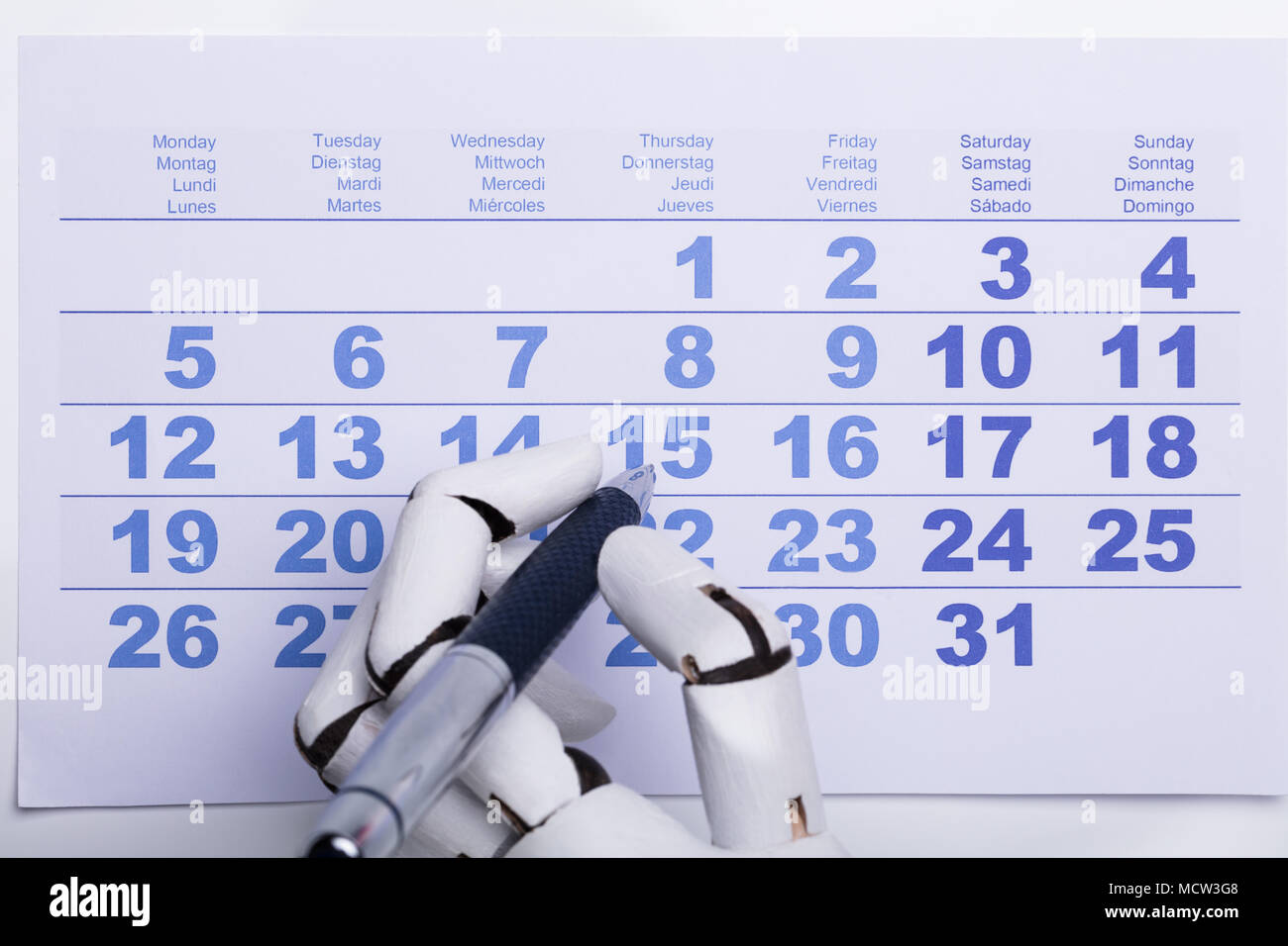Close-up Of A Robotic Hand Marking Date On Calendar With Pen Stock ...