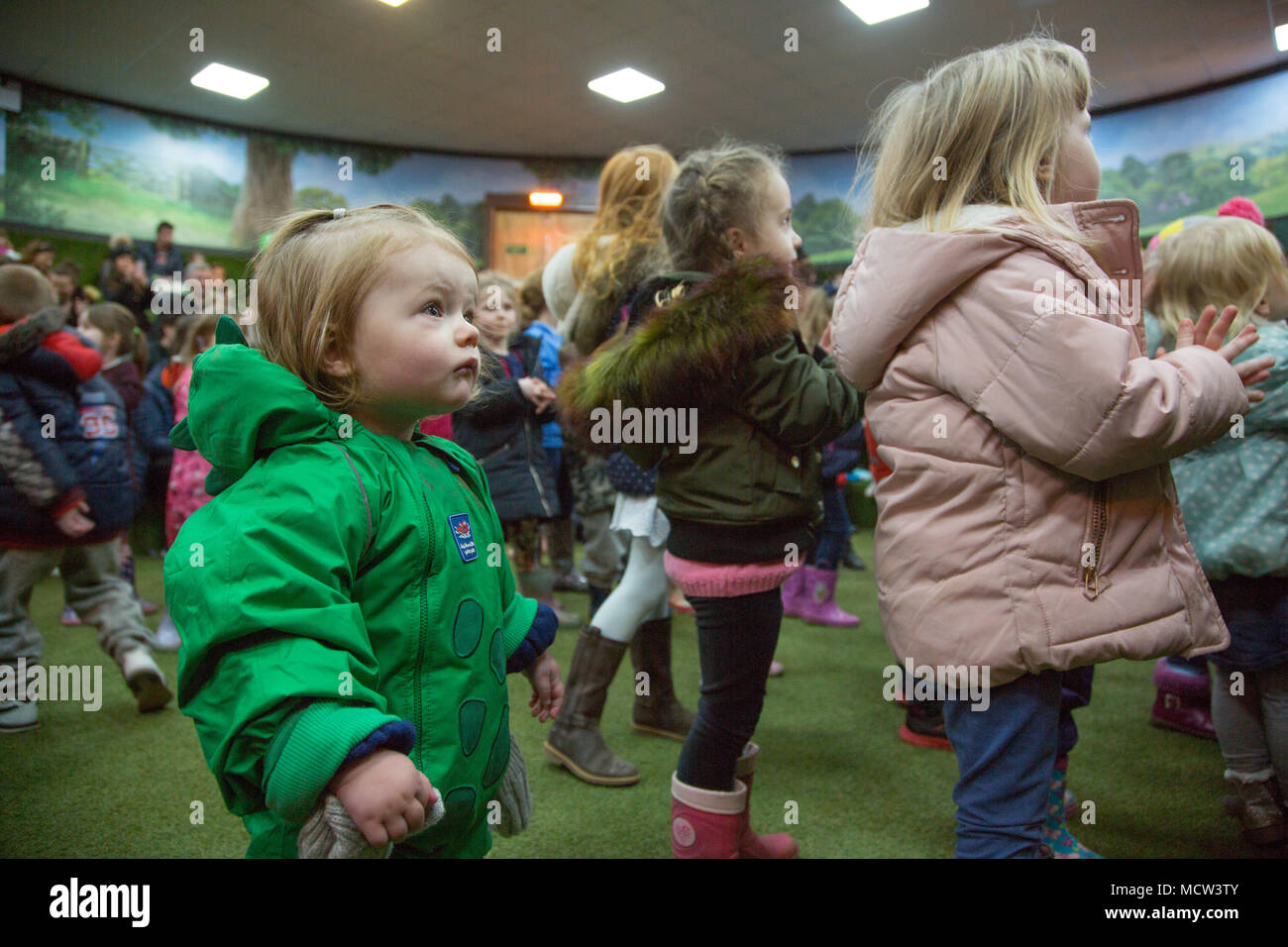 Children in winter coats enjoying an indoor show Stock Photo - Alamy