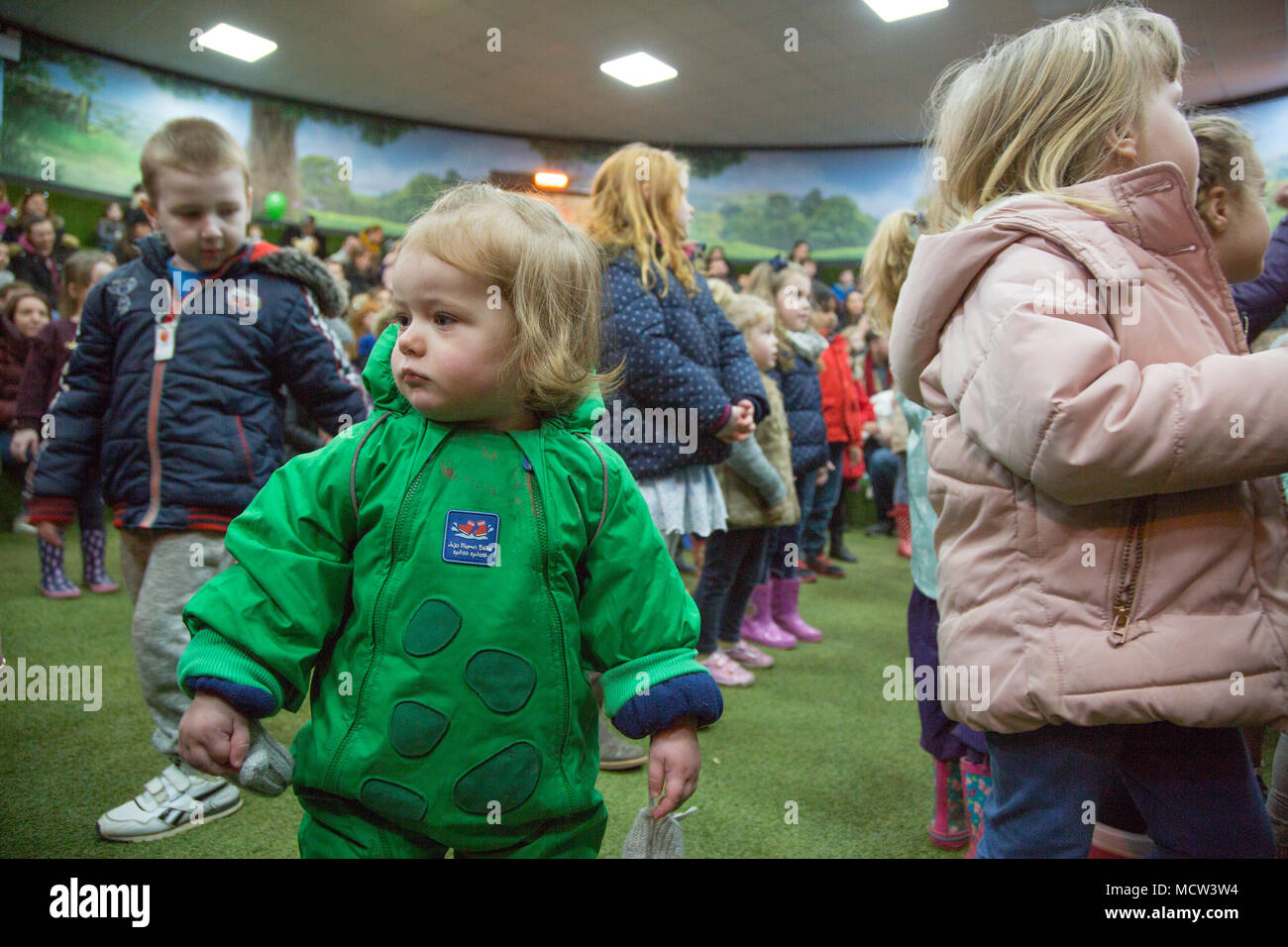 Children in winter coats enjoying an indoor show Stock Photo - Alamy