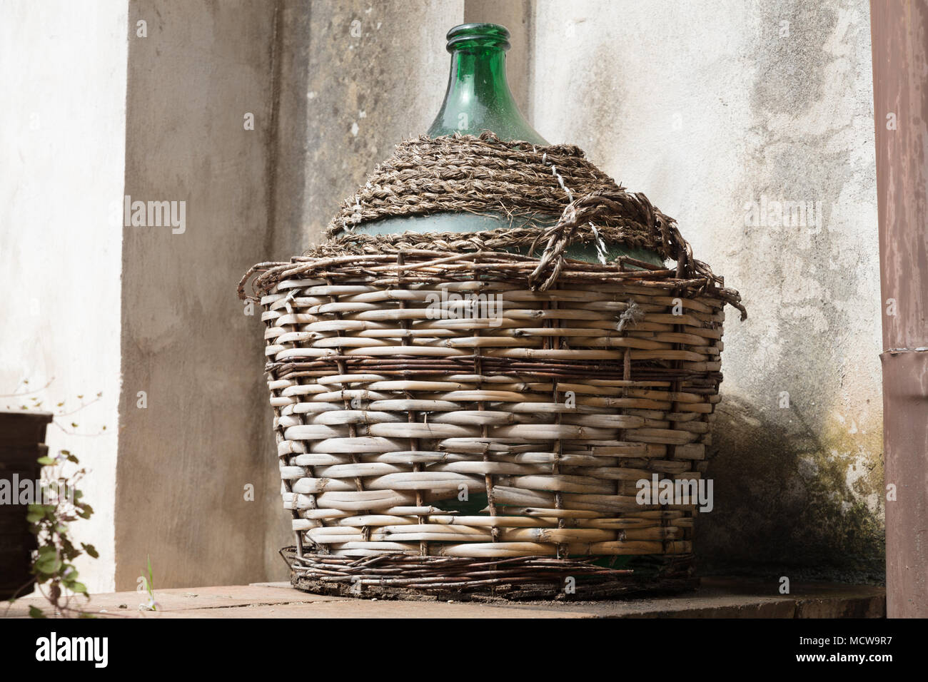 Empty carboy in rustic house, leaning against the wall Stock Photo - Alamy
