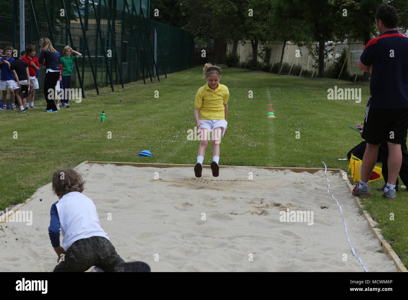 Girl doing the Long Jump at School Sports Day England Stock Photo - Alamy