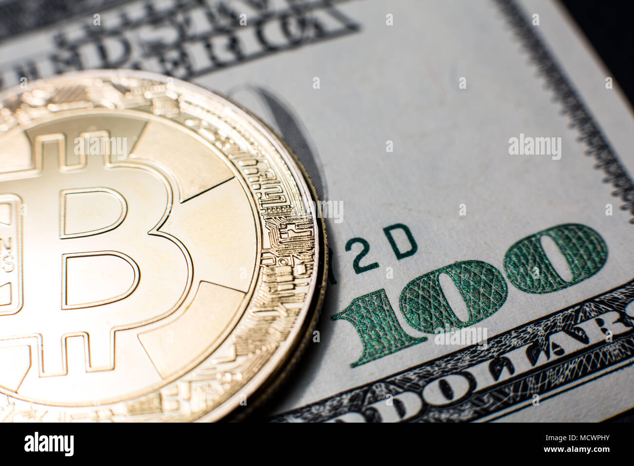 Bitcoin. Gold Bitcoins on a one hundred dollar bill close up Stock ...