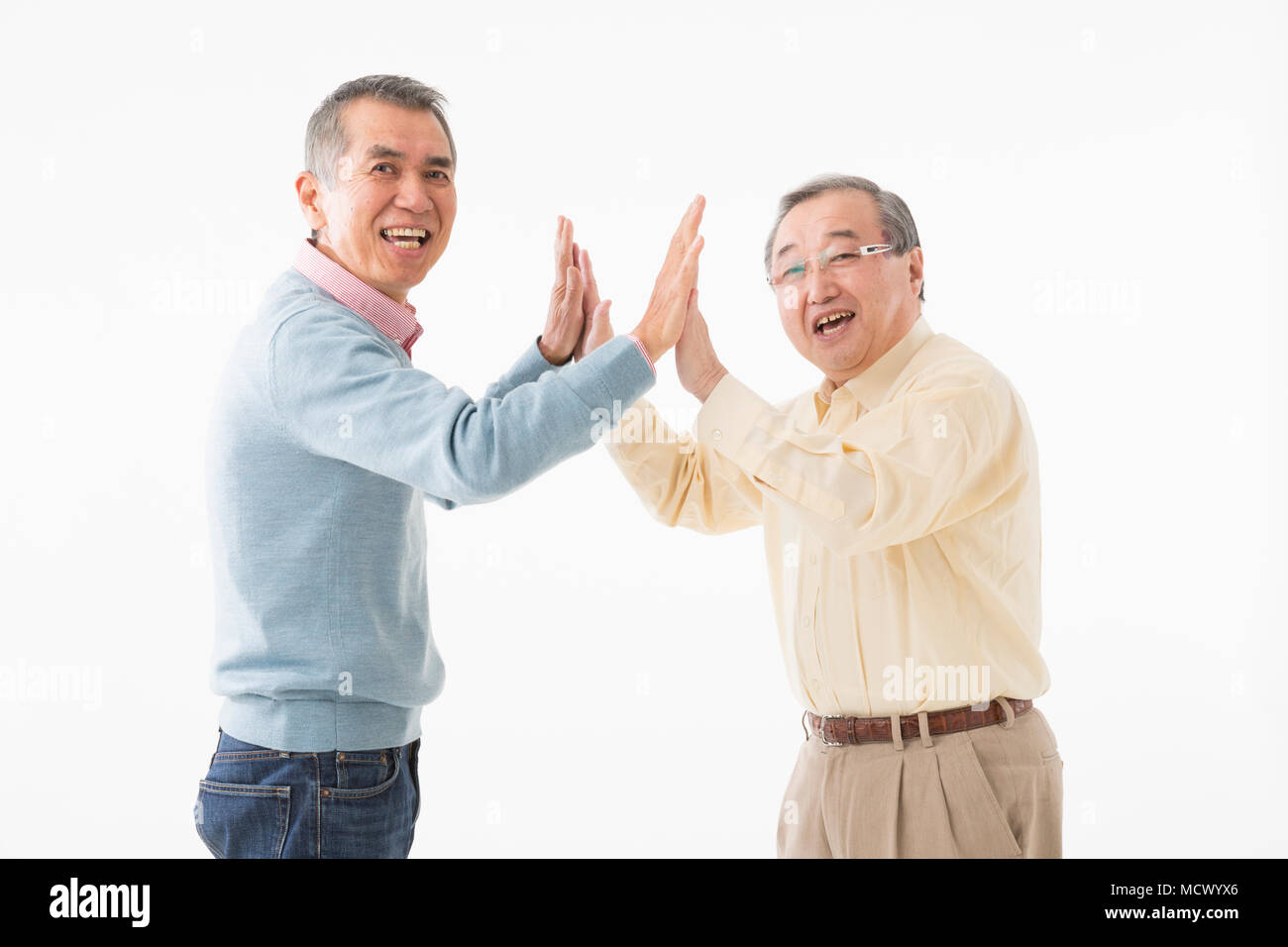 Two senior men high fiving Stock Photo - Alamy