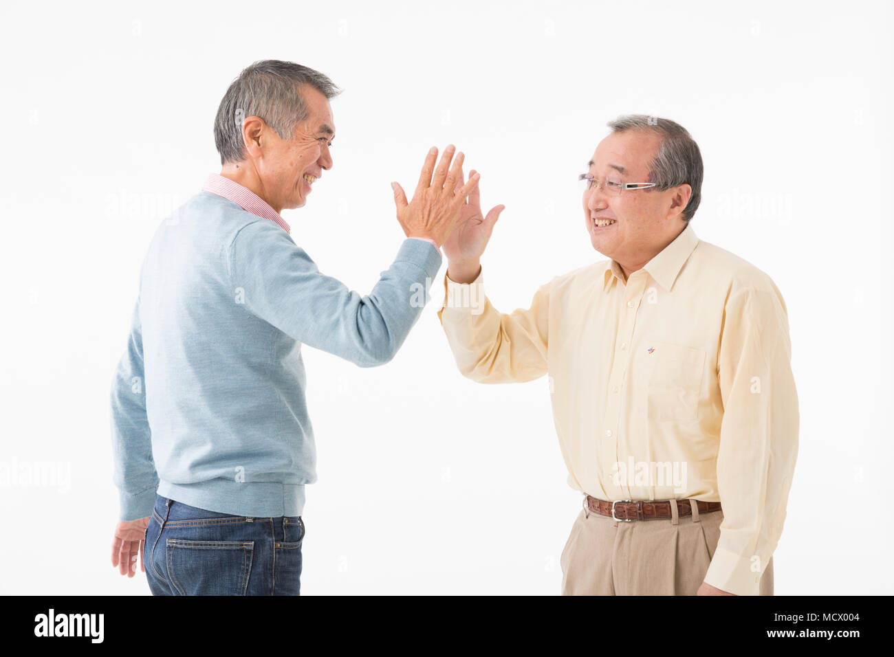 Two senior men high fiving Stock Photo - Alamy