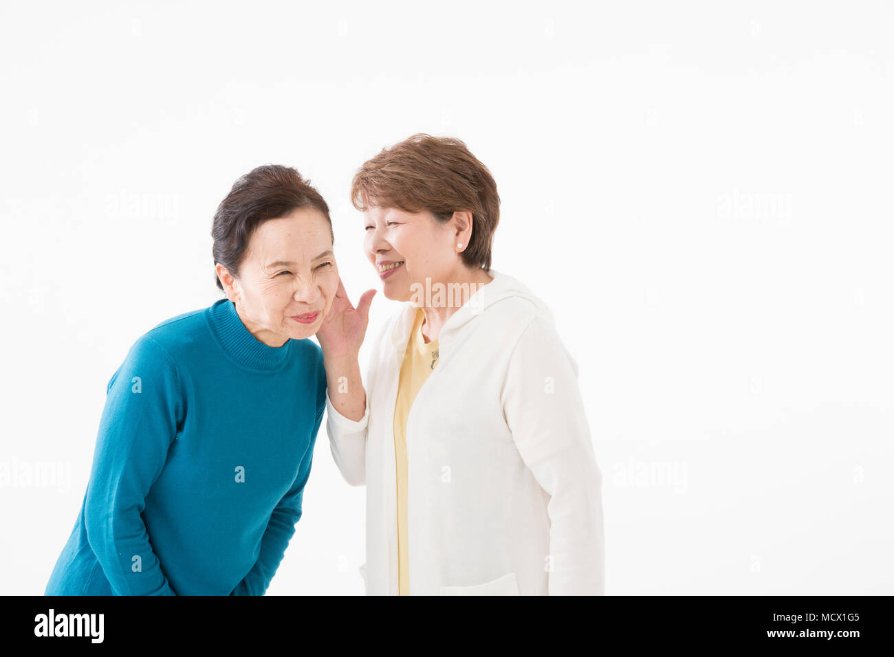 Two senior women whispering Stock Photo - Alamy