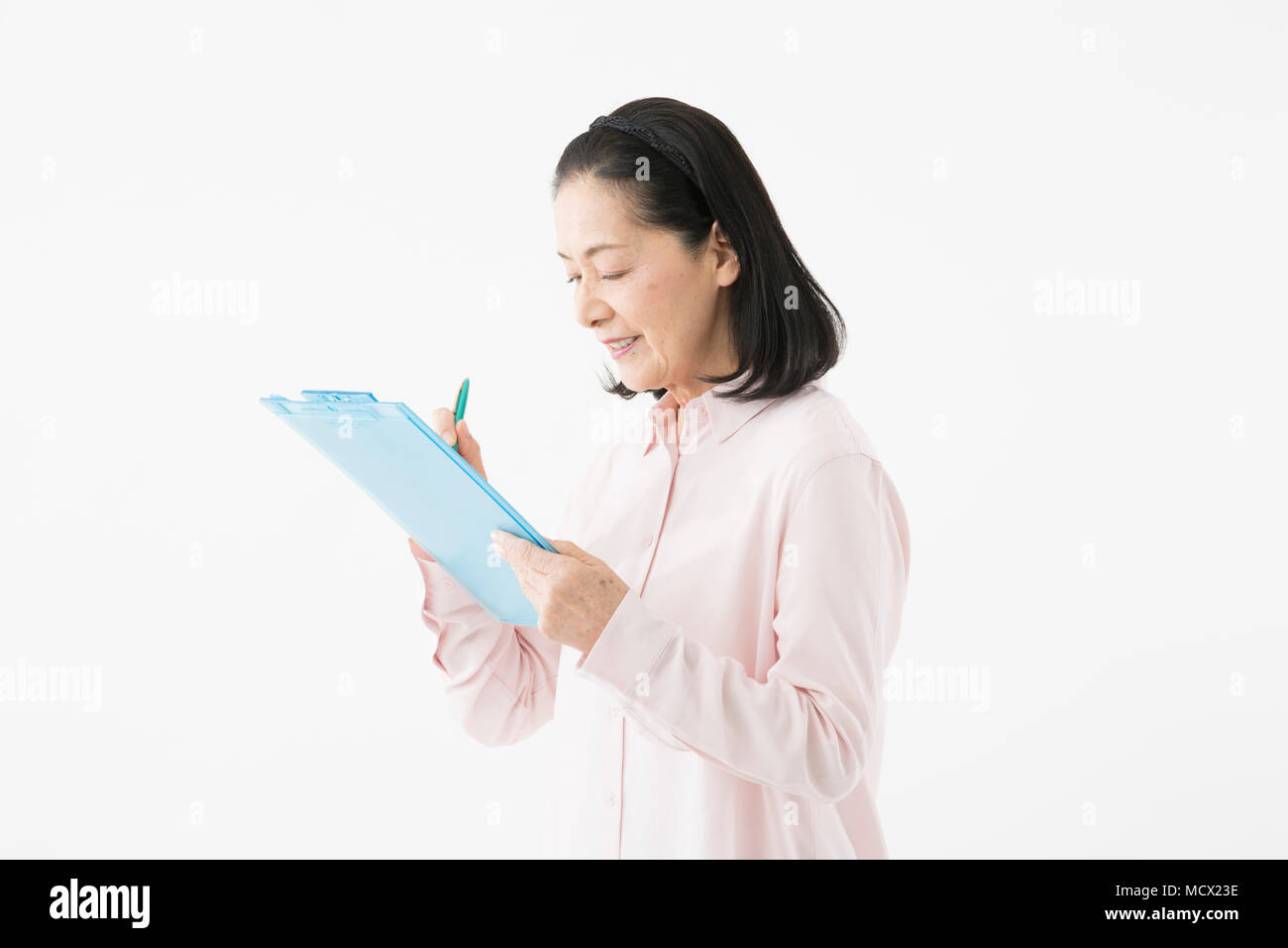 Senior woman answering questionnaire Stock Photo - Alamy