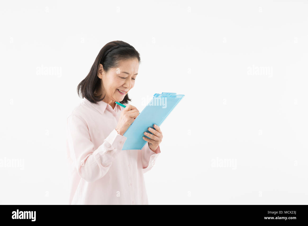Senior woman answering questionnaire Stock Photo - Alamy