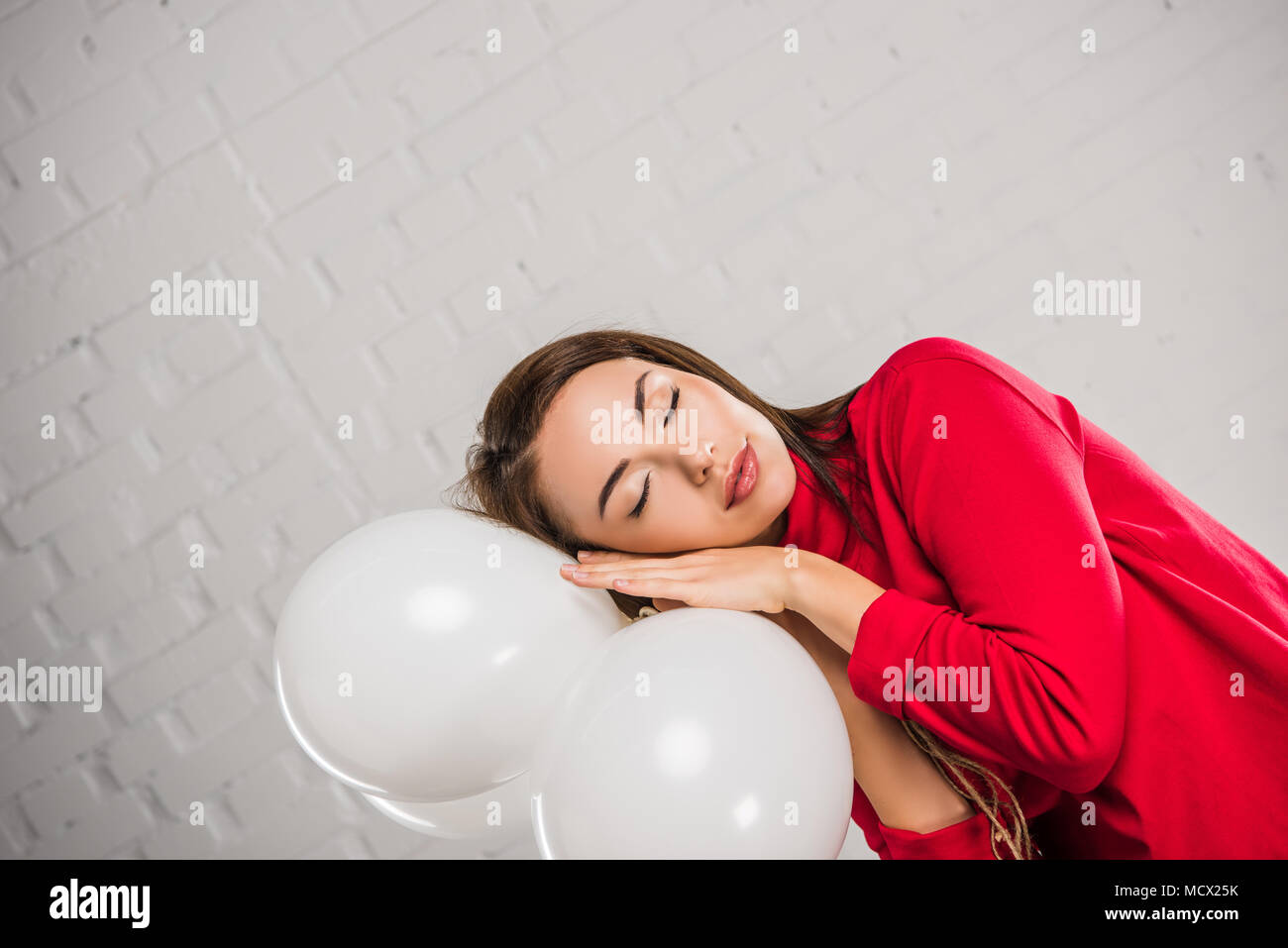 Woman posing and sleeping on white balloons Stock Photo - Alamy