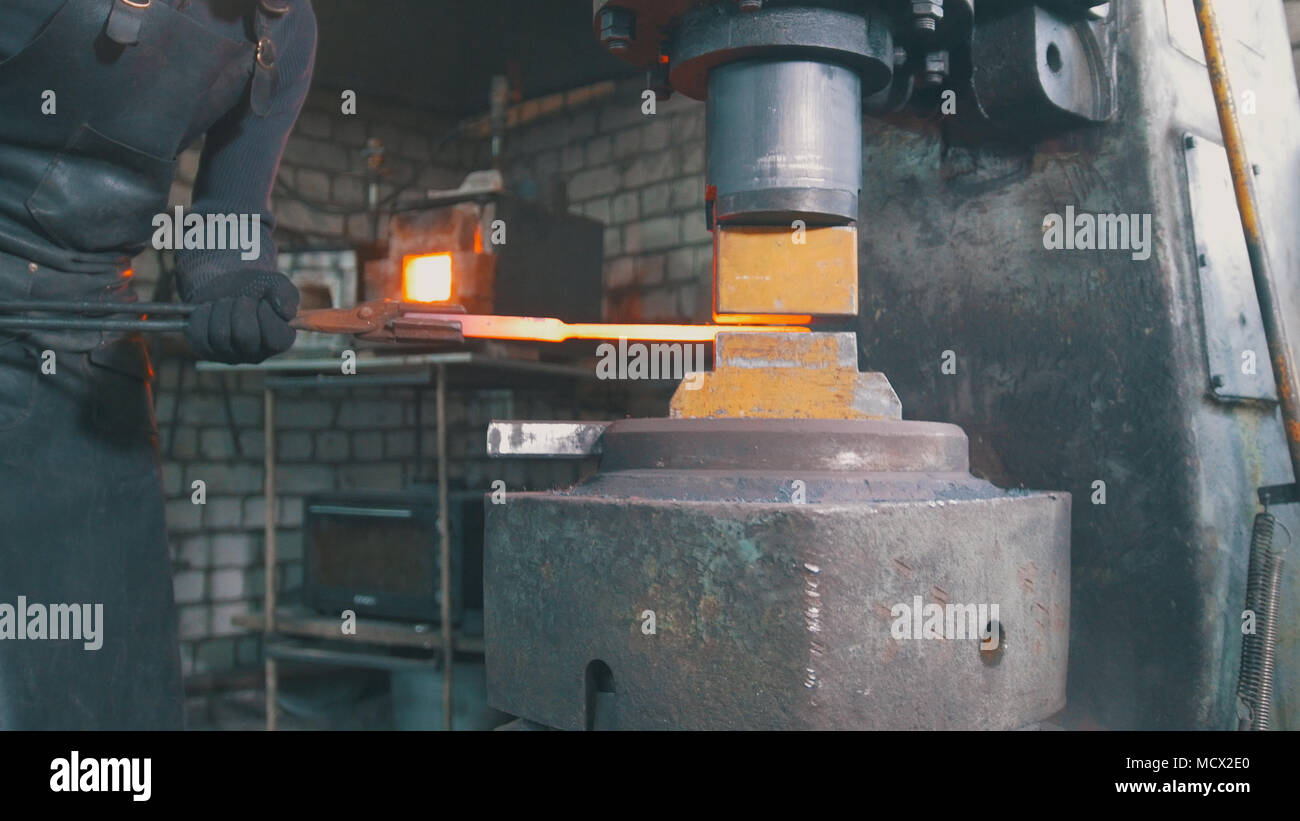Automatic hammering - blacksmith forging red hot iron on anvil, extreme ...