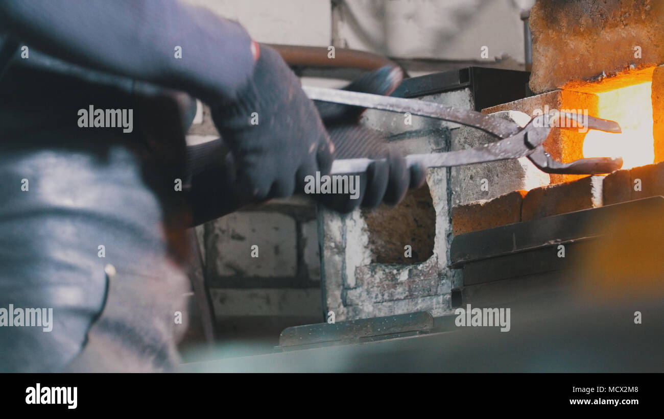 Craftsman blacksmith working with steel in forge Stock Photo - Alamy