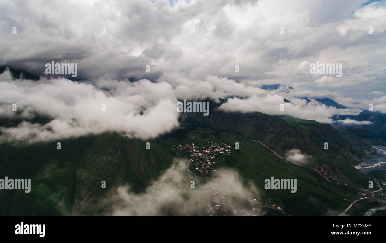 aerial view of city in green mountains with clouds, Georgia Stock Photo ...