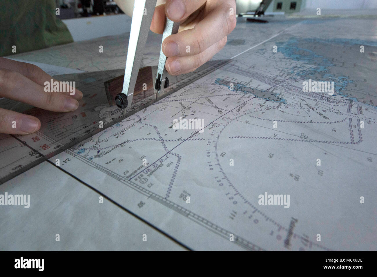 U.S. Civil Service Mariner Ship’s Navigator Jaime Rocco plots points on ...