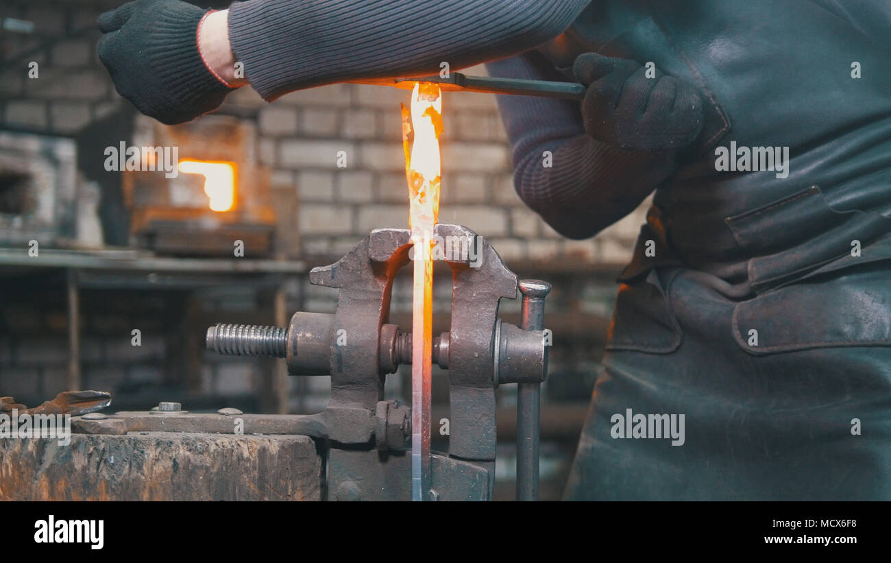 Muscular blacksmith in forge hammering steel products Stock Photo - Alamy