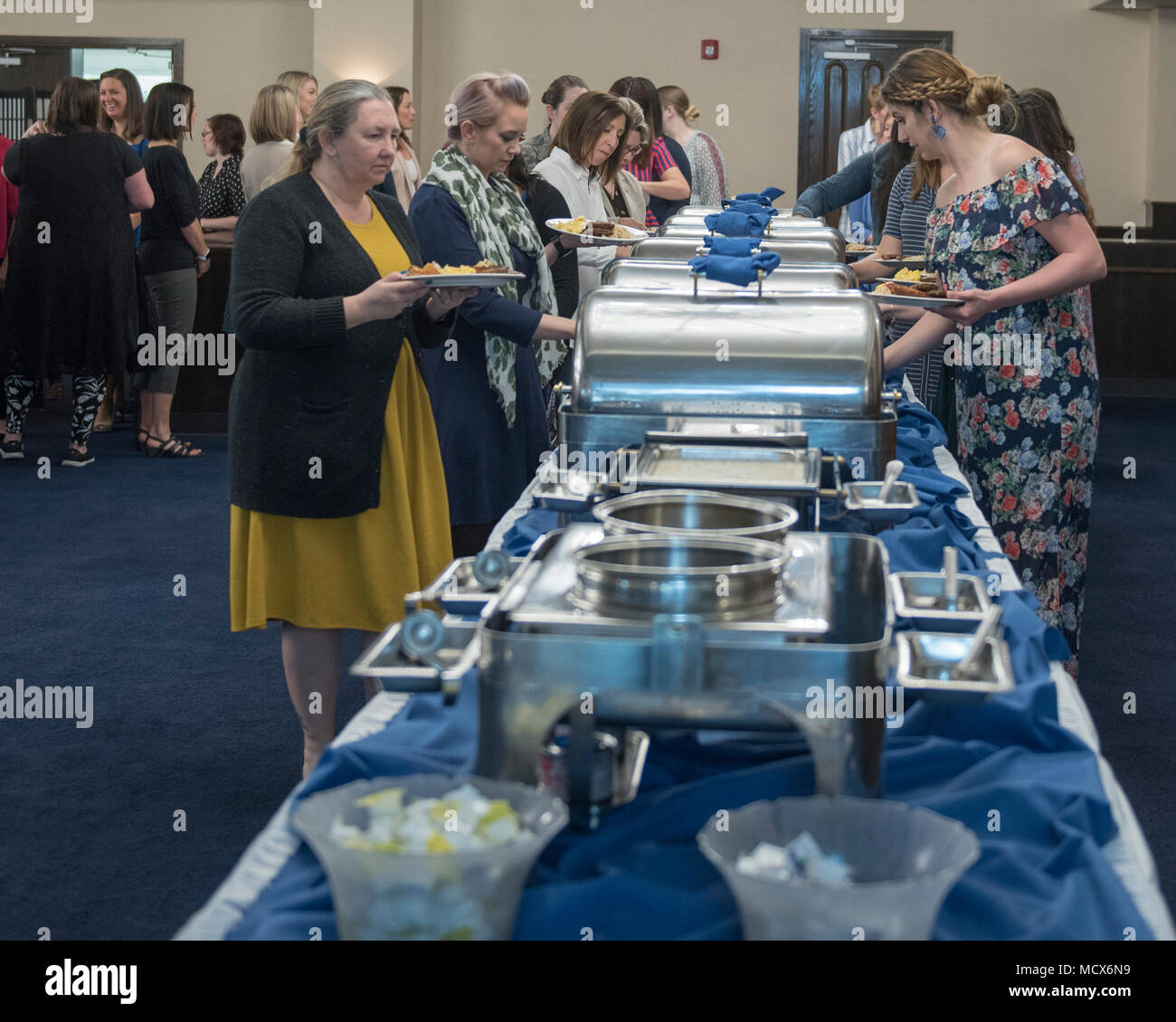 Attendees listen to an announcement during a Key Spouse appreciation ...