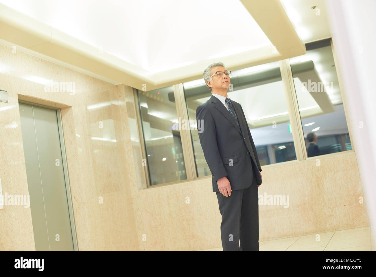 Senior businessman waiting for lift Stock Photo - Alamy