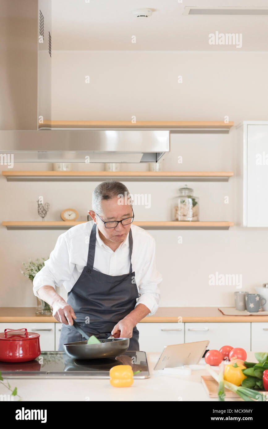 Scene of Senior man cooking Stock Photo - Alamy