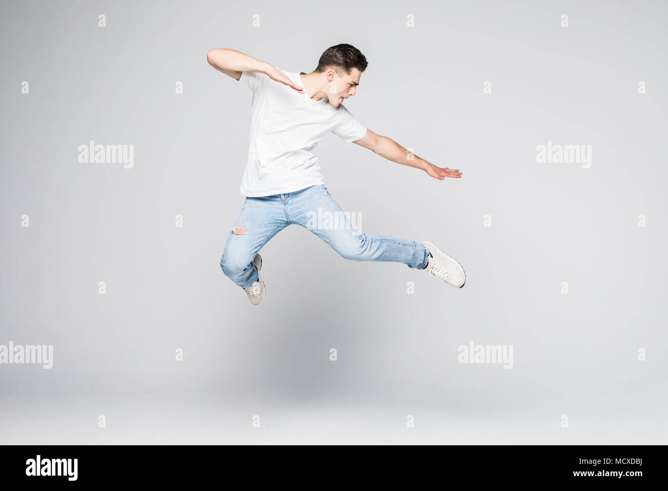 Cheerful handsome man jumping over white background Stock Photo - Alamy