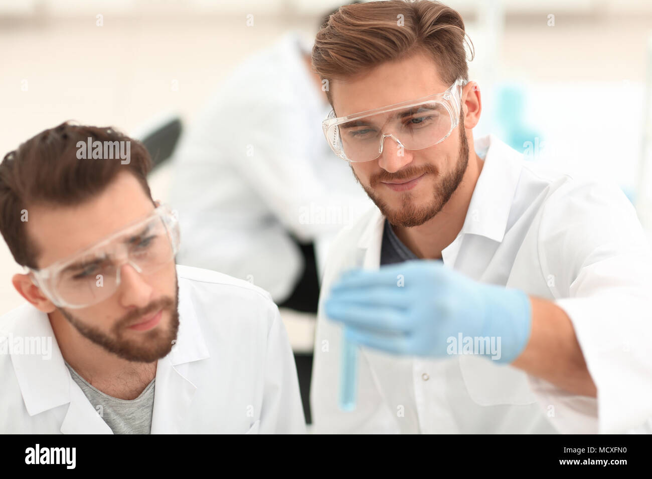 two scientists examining liquid in a test tube Stock Photo - Alamy