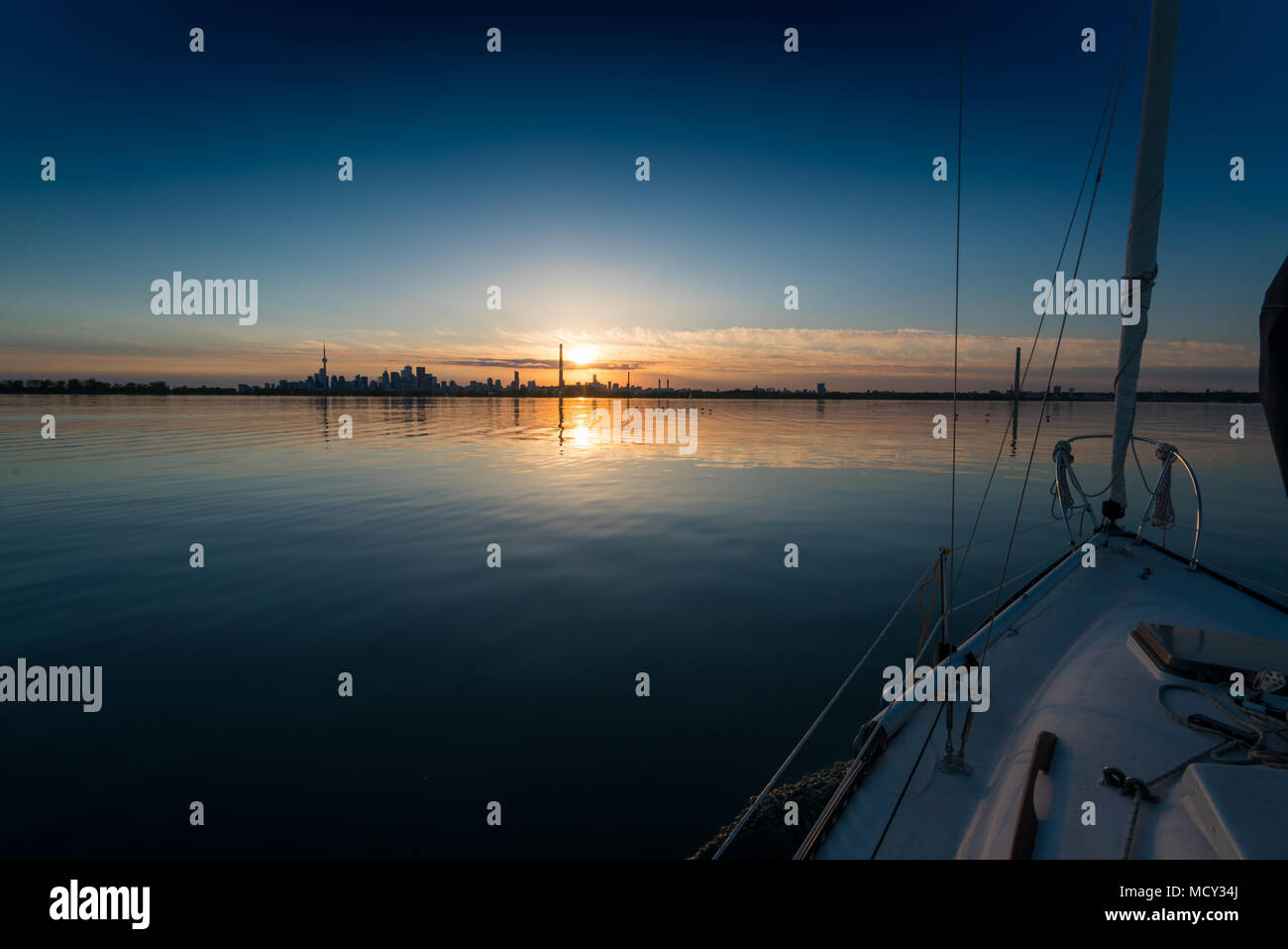 Sailboat on ocean with skyline at distant during sunset, Toronto ...