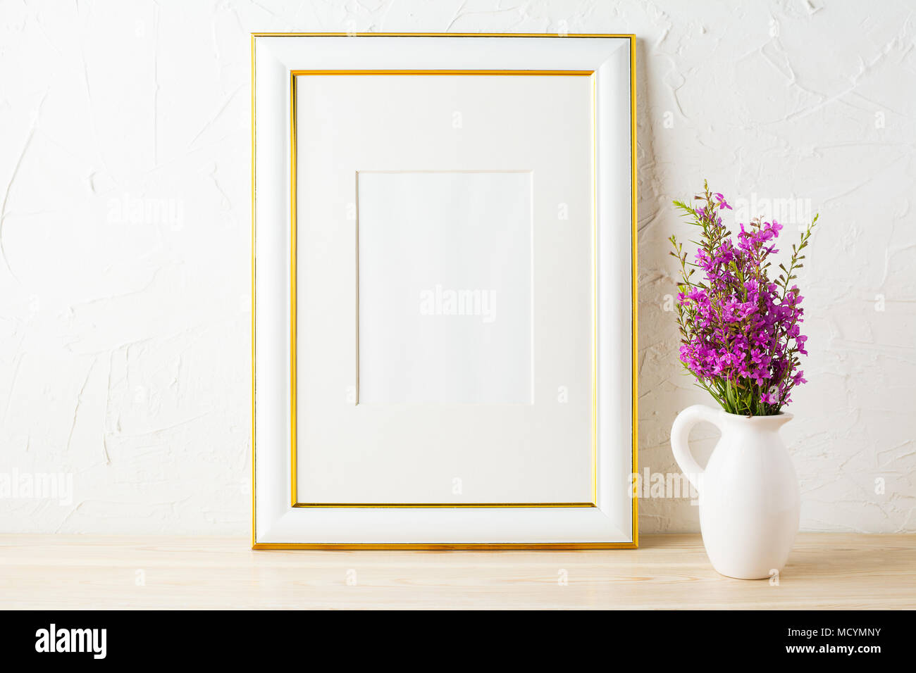 Gold decorated frame mockup with purple wildflowers in the small ...