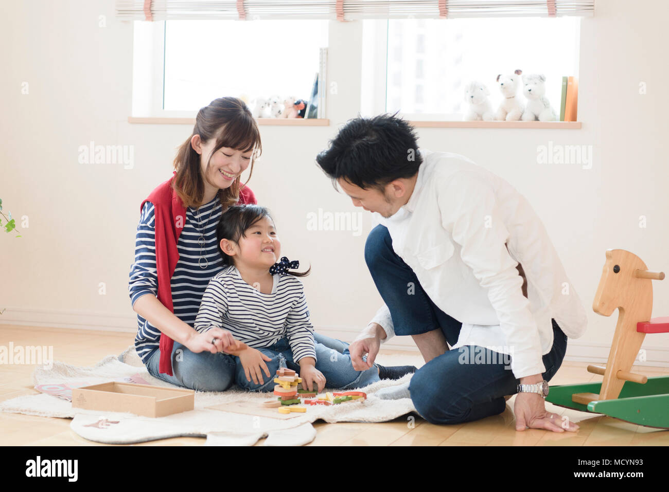 Parents and child playing in kids room Stock Photo - Alamy