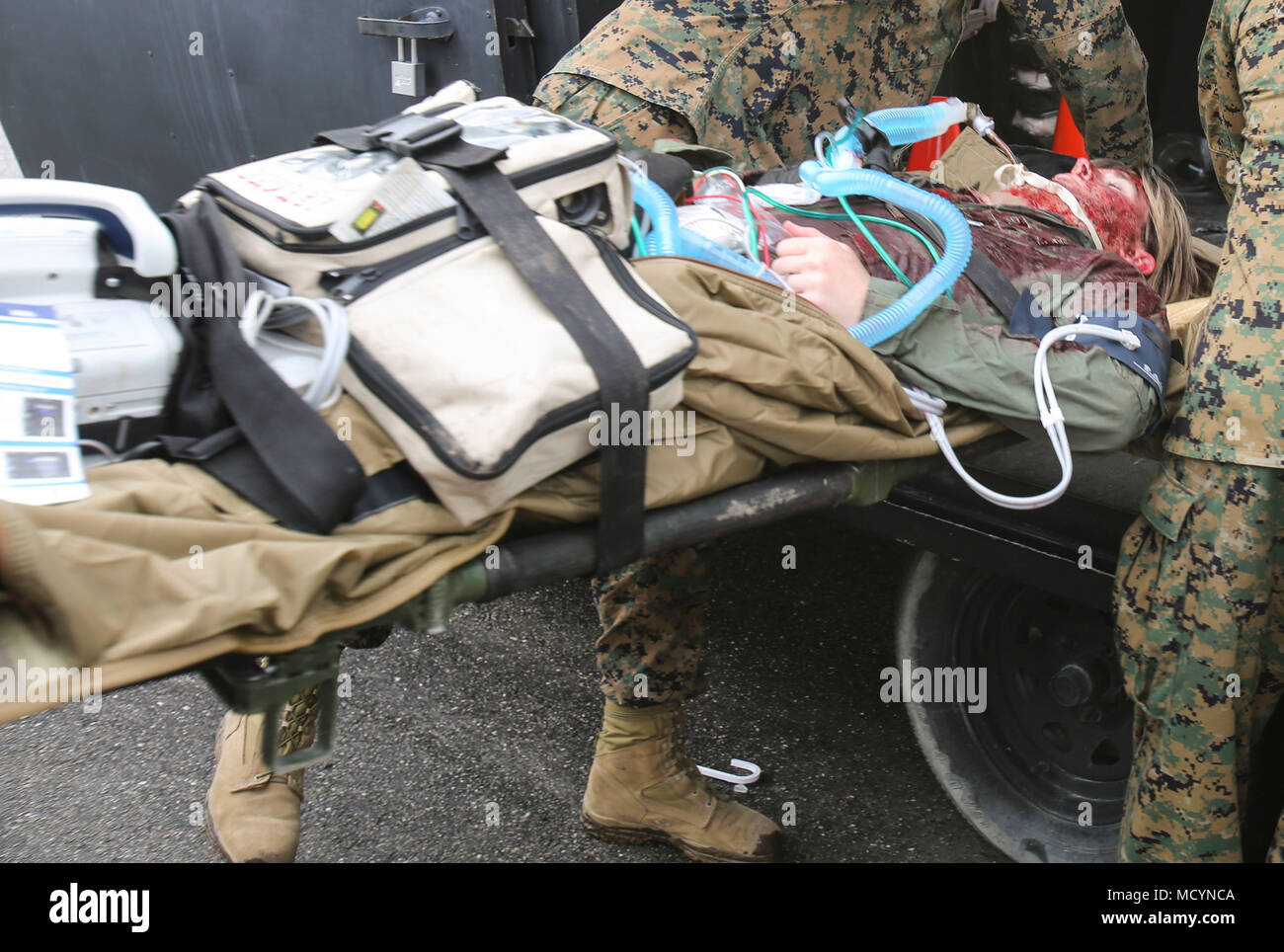 A U.S. service member is loaded onto an aircraft after being stabilized ...