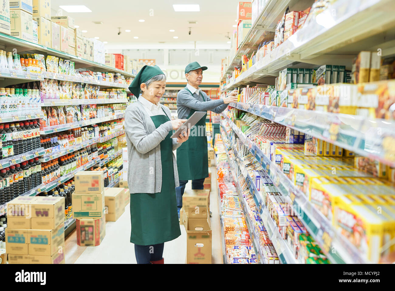 Senior man and woman worker checking stocks at supermarket Stock Photo ...