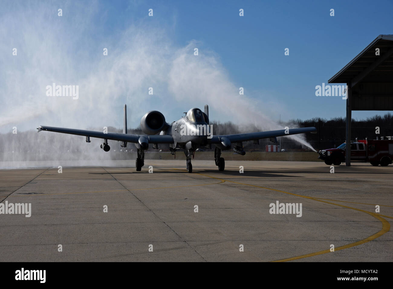 An A-10C Thunderbolt II aircraft is sprayed by two firetrucks as it ...
