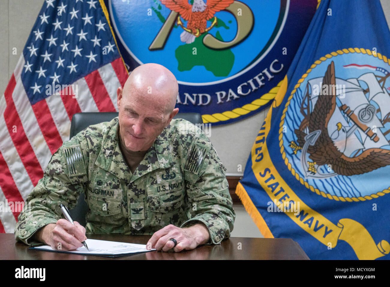 Commander, Task Force 75, Capt. Bob Baughman signs a search and rescue ...