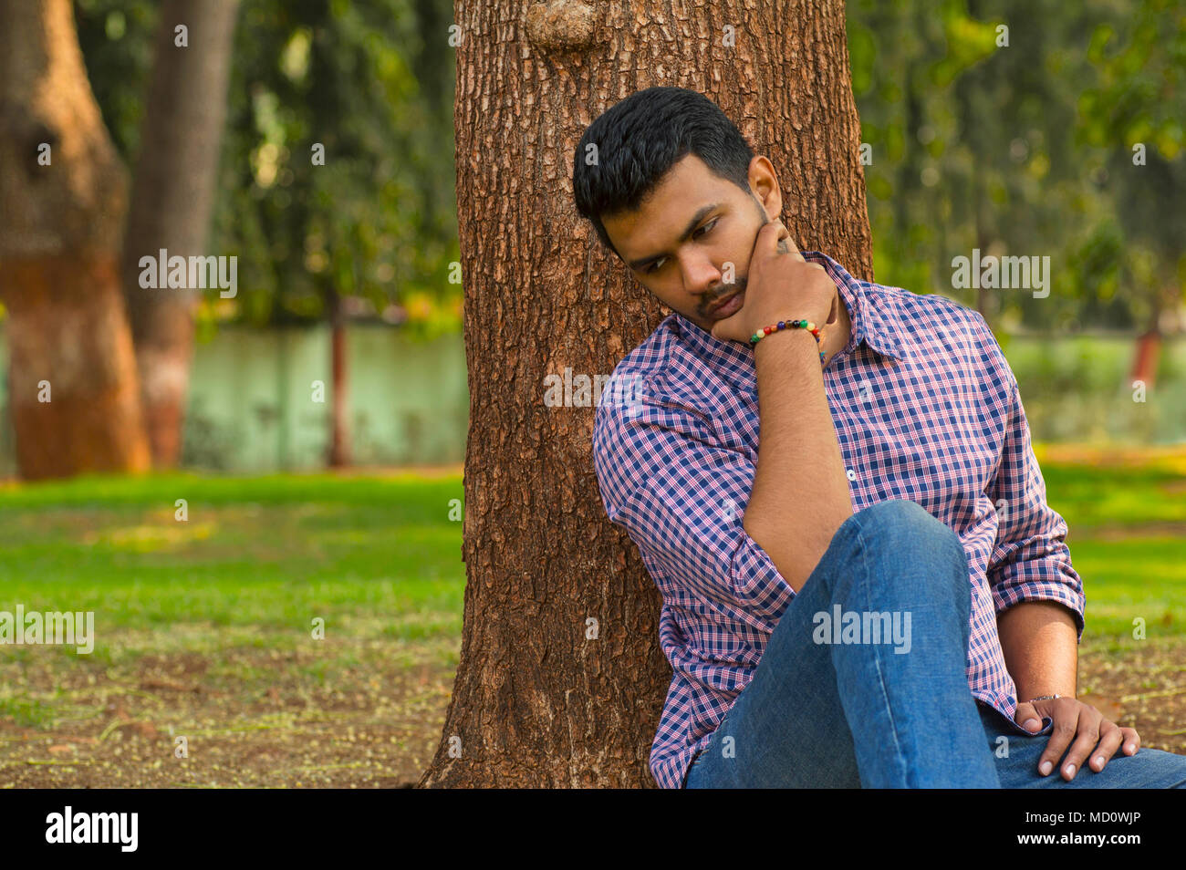 Boy leaning against tree hi-res stock photography and images - Alamy