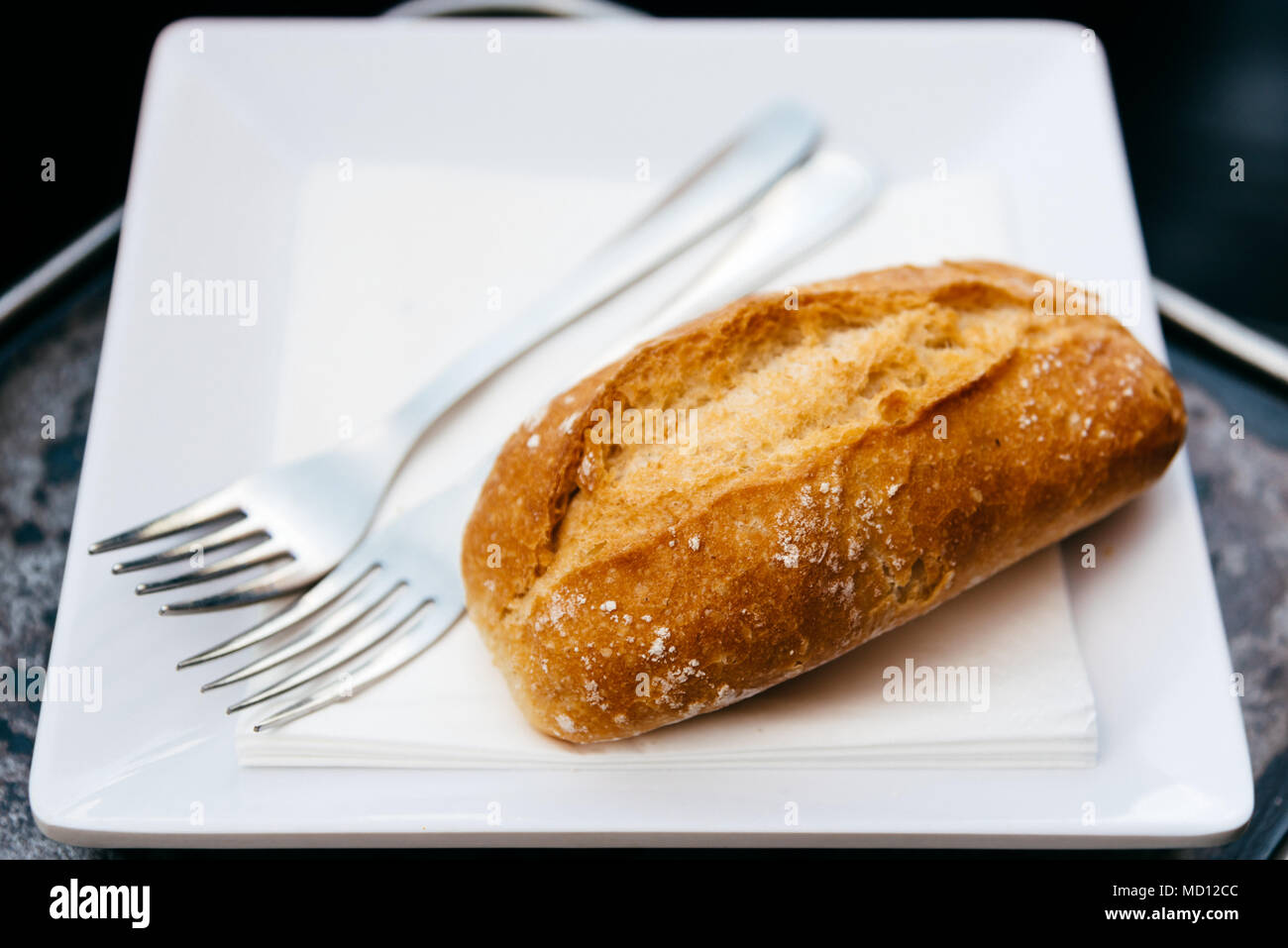 Close up of bread and forks on white plate Stock Photo - Alamy