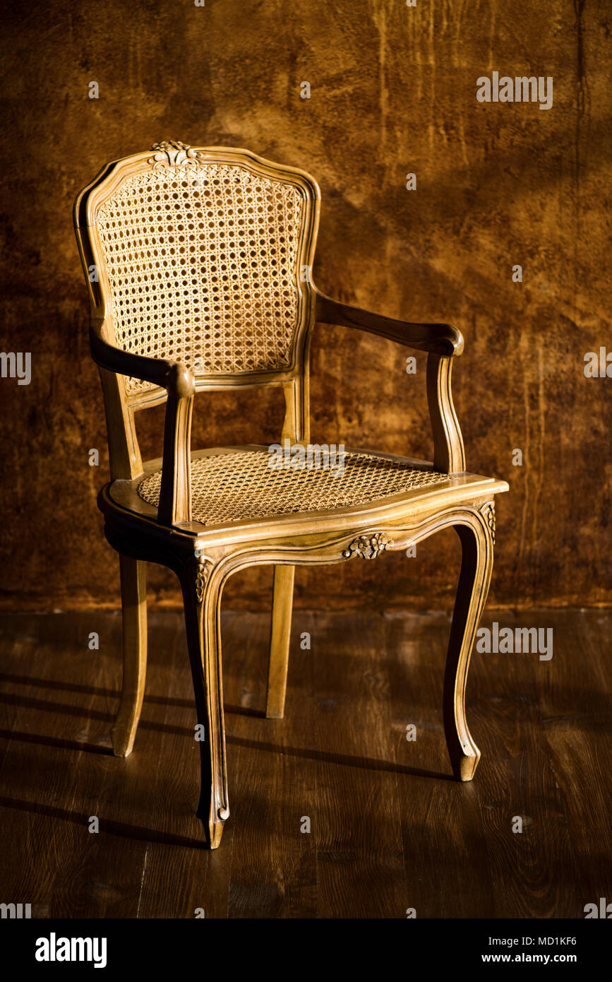 old chair on a brown wall background Stock Photo - Alamy