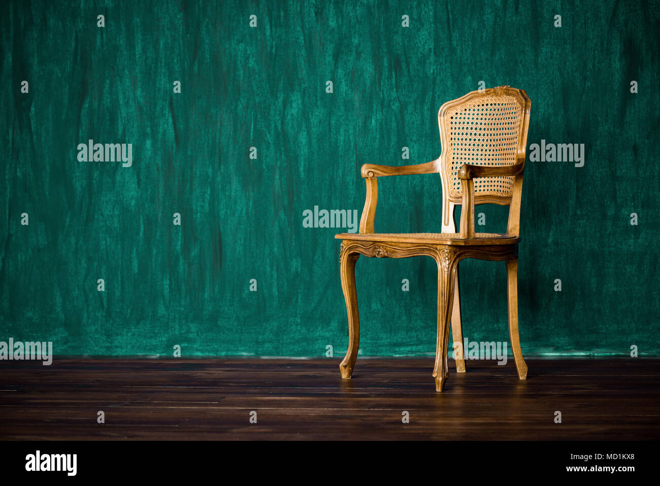 old chair on a green wall background Stock Photo - Alamy