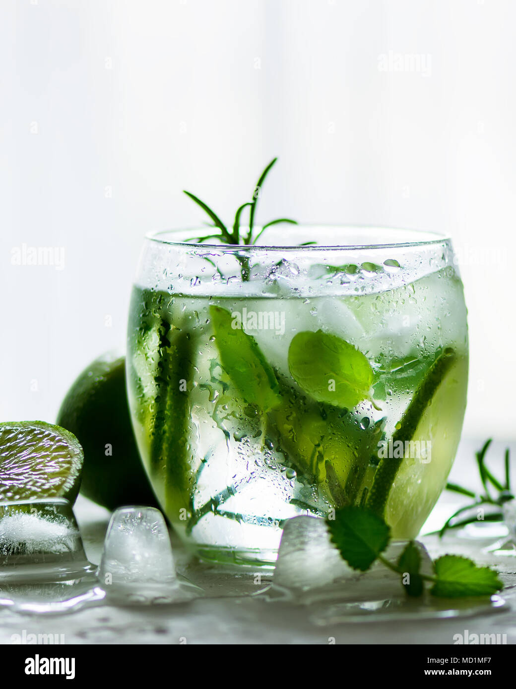 Homemade lime lemonade with cucumber, rosemary and ice, white ...