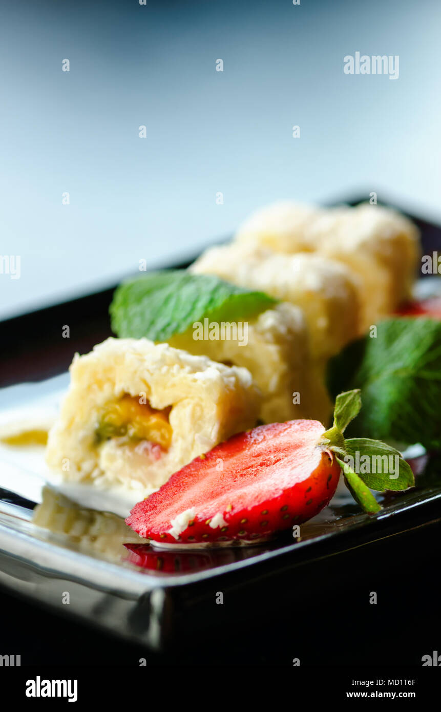 White sweet roll with kiwi, peaches, strawberries, mint. Serverd with ...