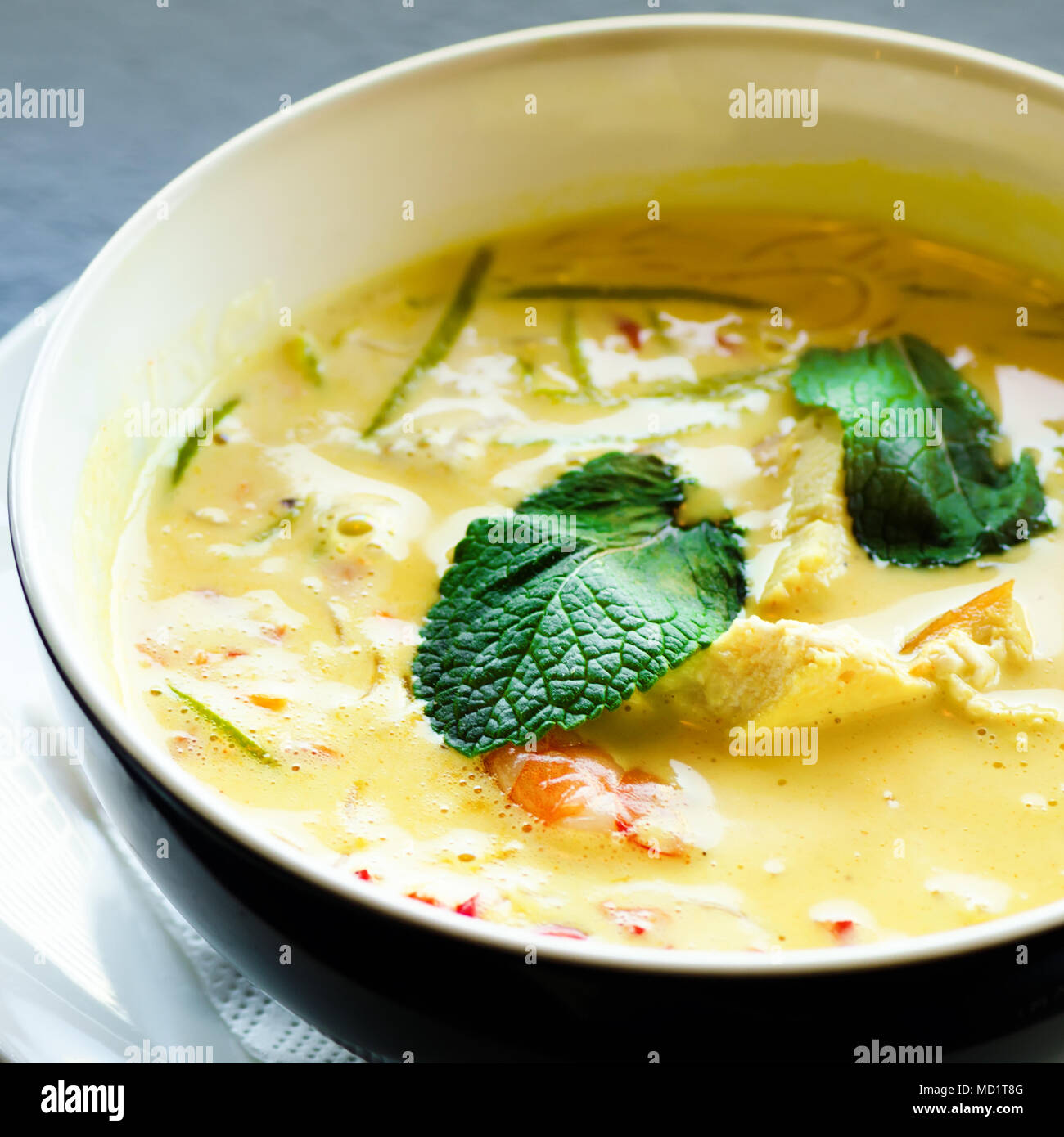 Spicy coconut milk cream soup curry with chiken, tiger prawns, long soy ...