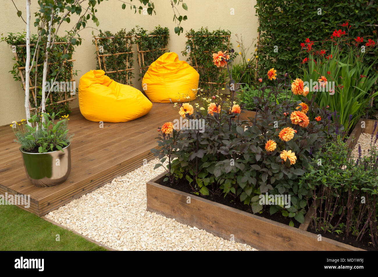 Bright colourful flowering plants in timber beds & yellow beanbag ...