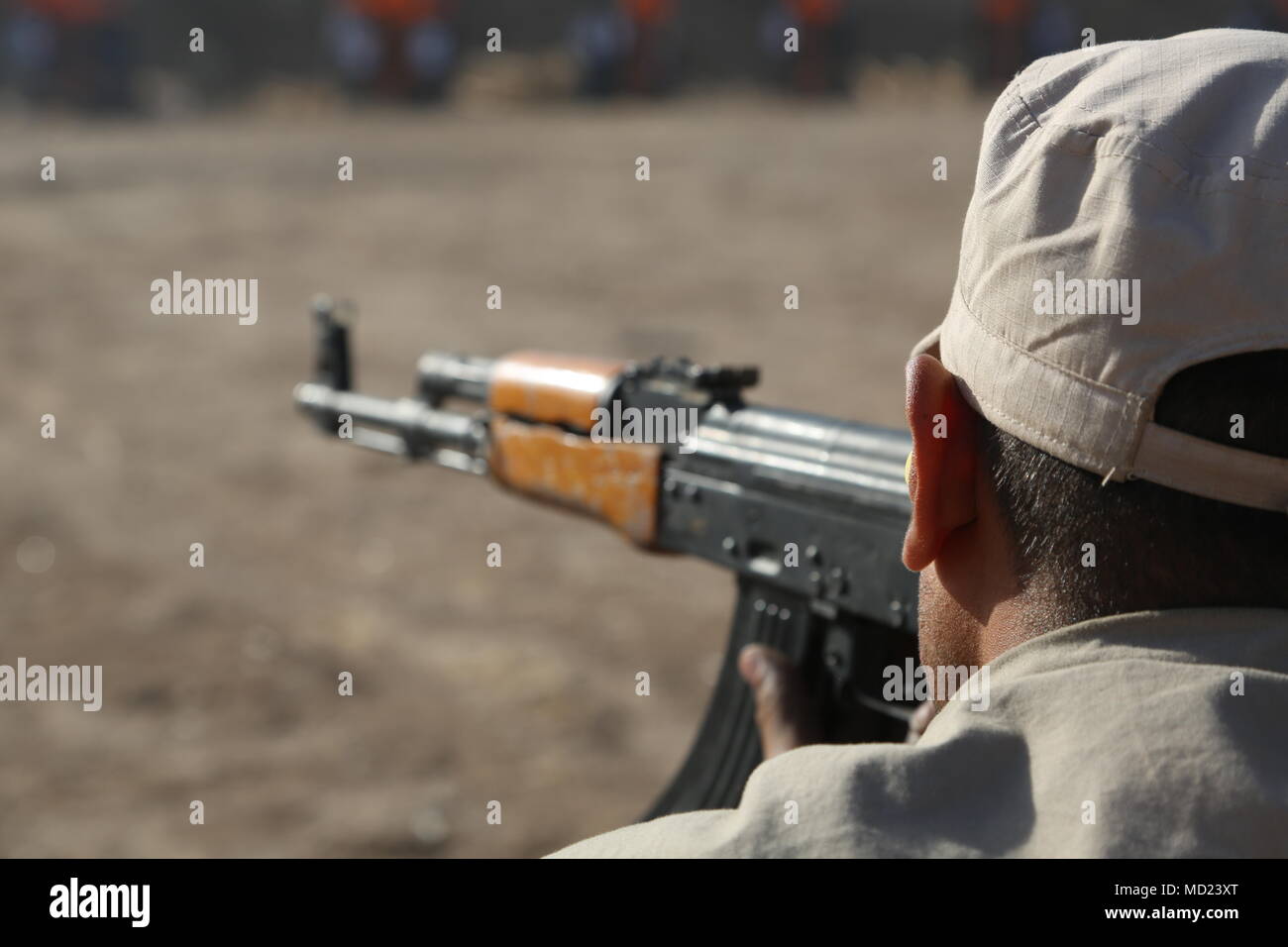 An Iraqi soldier with the Desert Battalion, aims his AK47 at a target ...