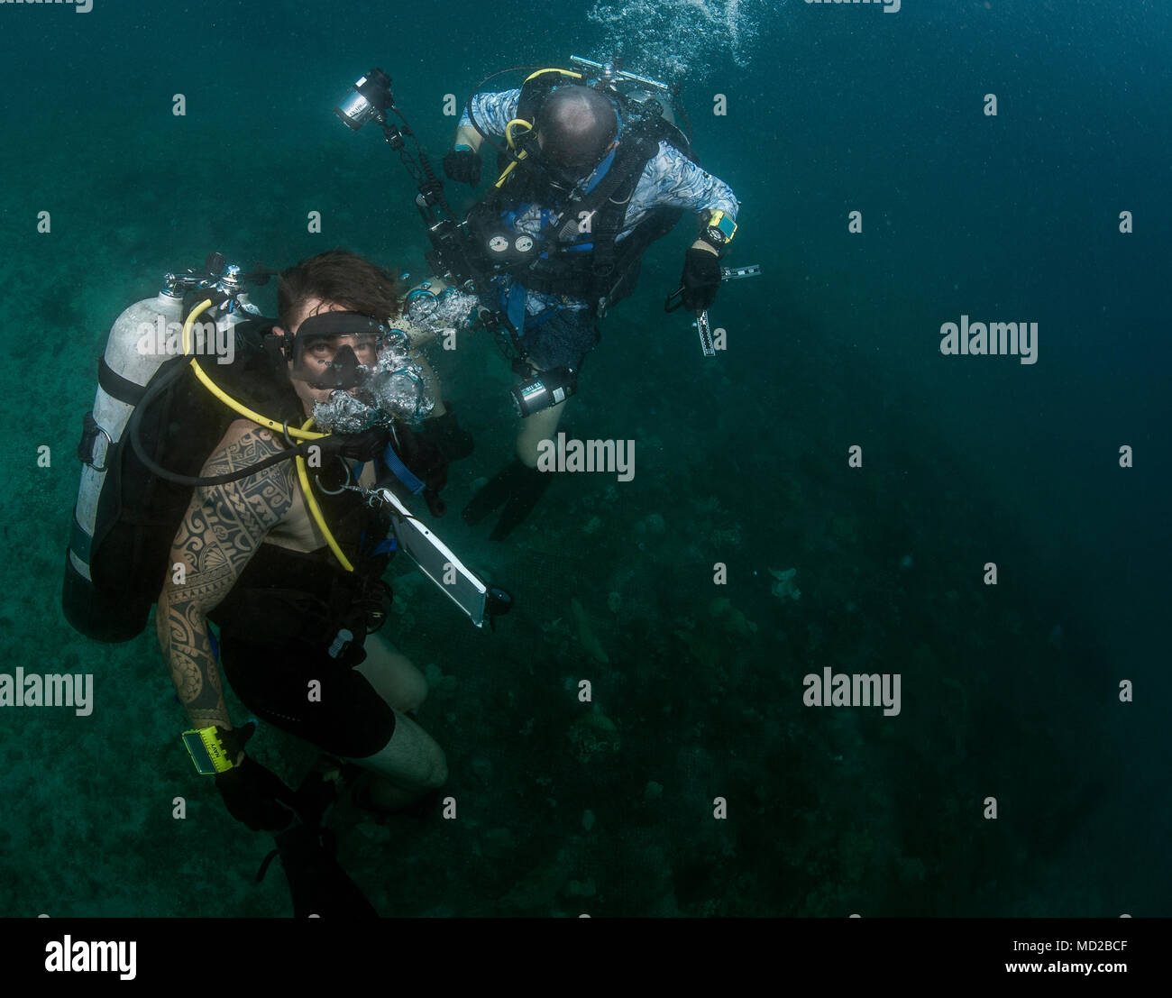 Navy Diver 1st Class Jesse Stigibauer, left, assigned to the Naval Base ...