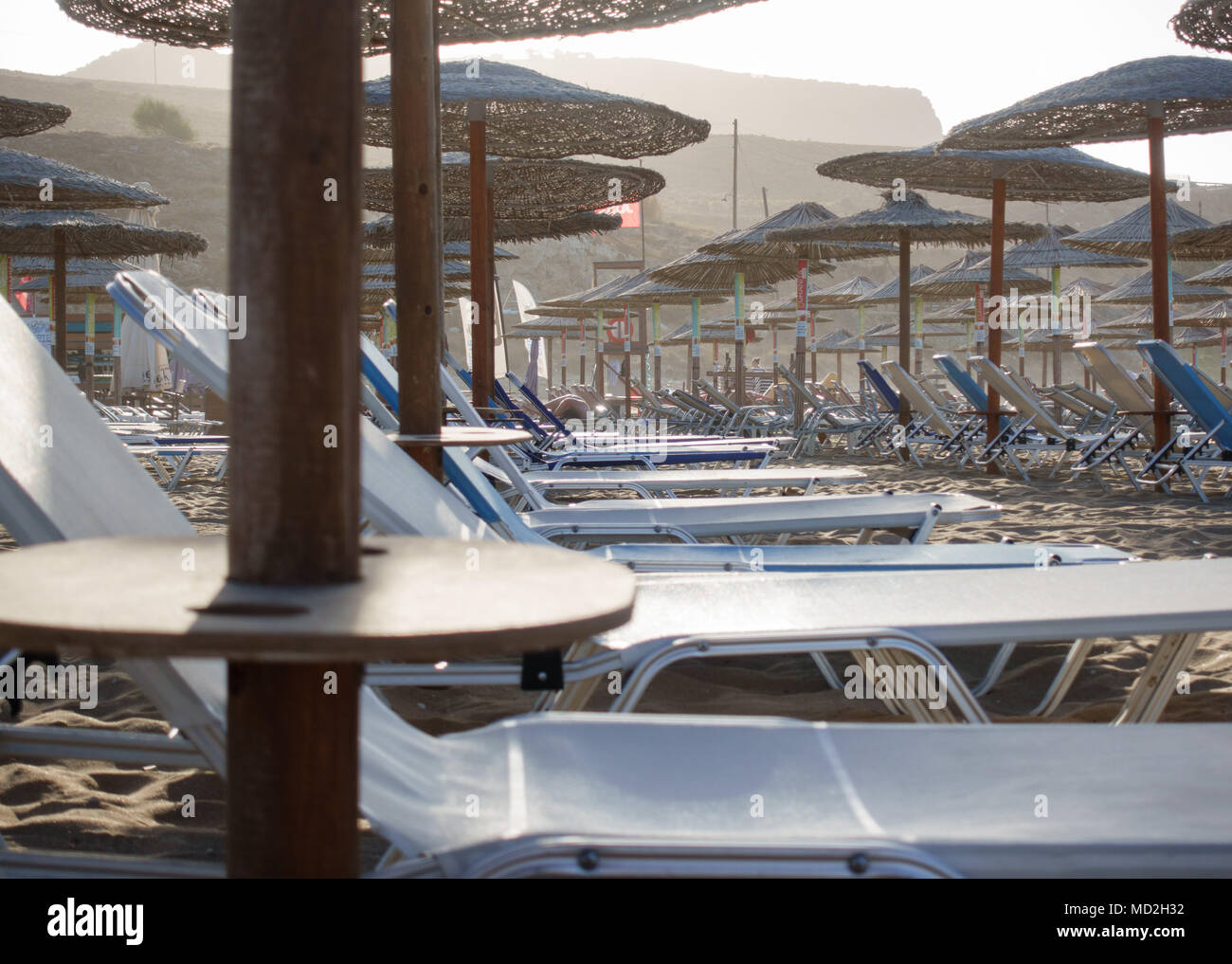 View of beach lounge chairs and parasols on sand Stock Photo - Alamy