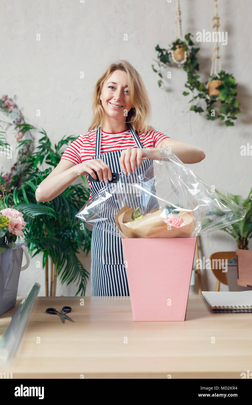 Image of female florist with stapler decorating floral composition at ...