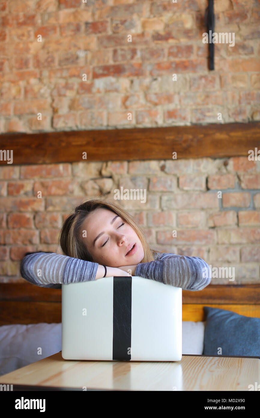 Young girl sleeping near laptop at cafe Stock Photo - Alamy