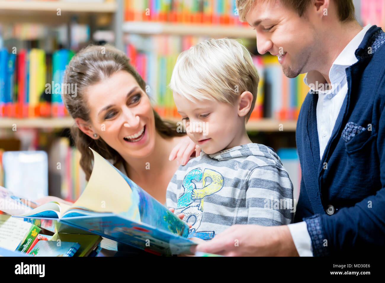 Family reading a book in the library Stock Photo - Alamy